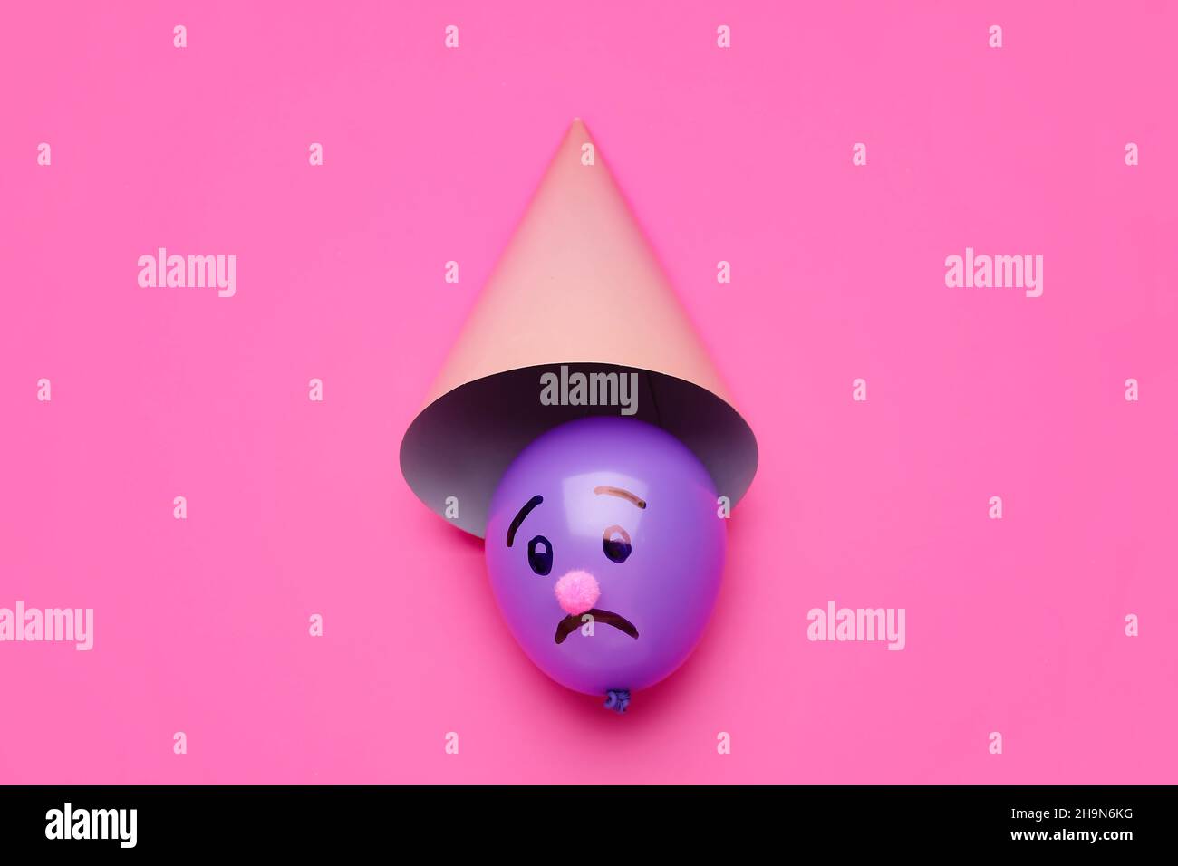 Beautiful balloon with drawn sad face and hat on pink background Stock ...