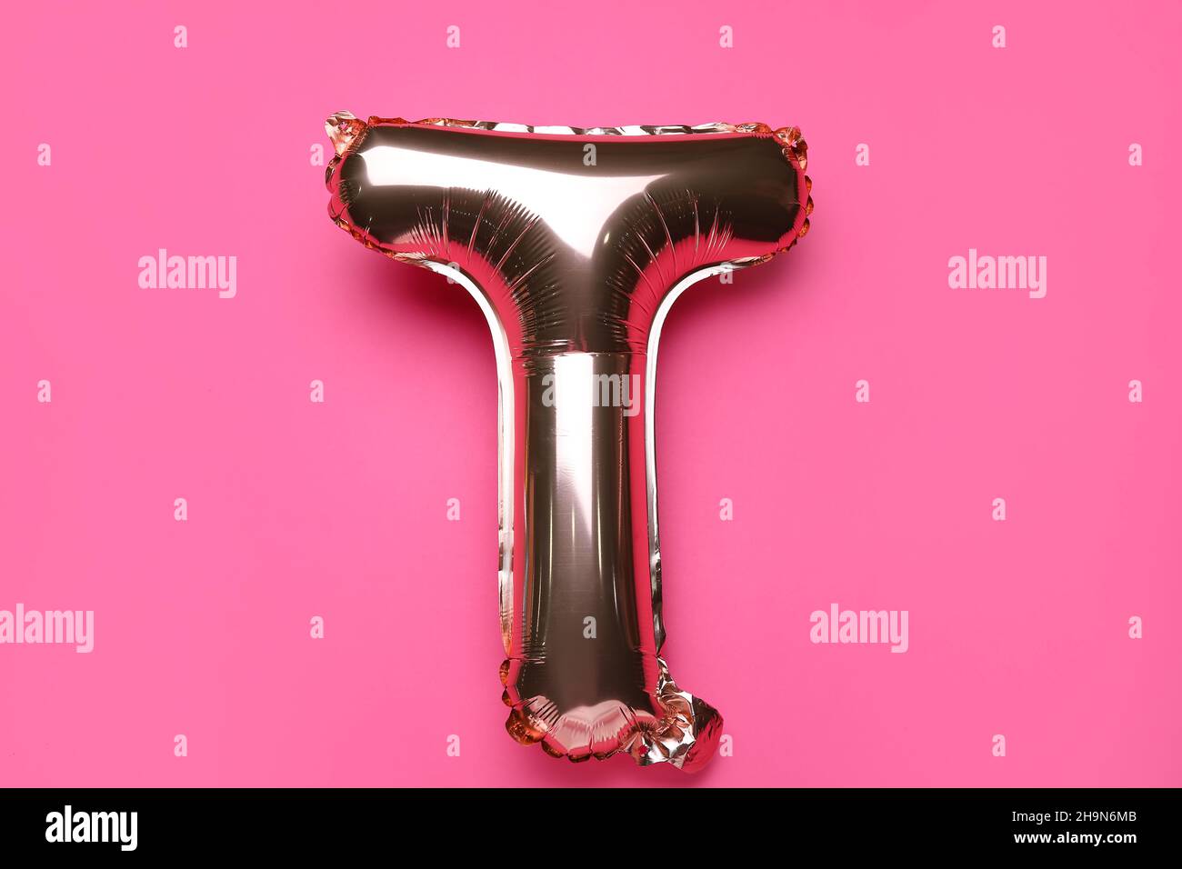 Balloon in shape of letter T on pink background Stock Photo - Alamy