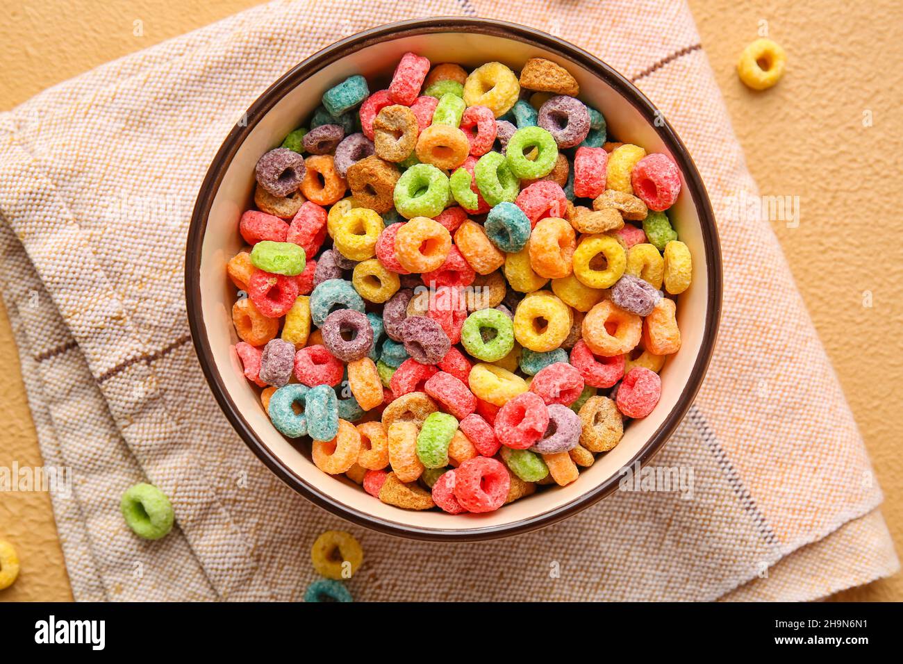 Bowl of colorful cereal rings on color background Stock Photo - Alamy