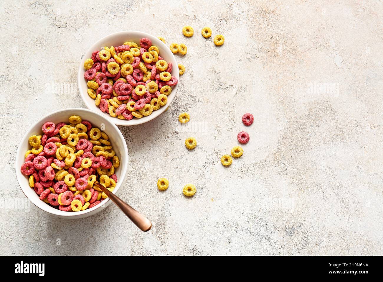 Bowls of colorful cereal rings on light grunge background Stock Photo ...