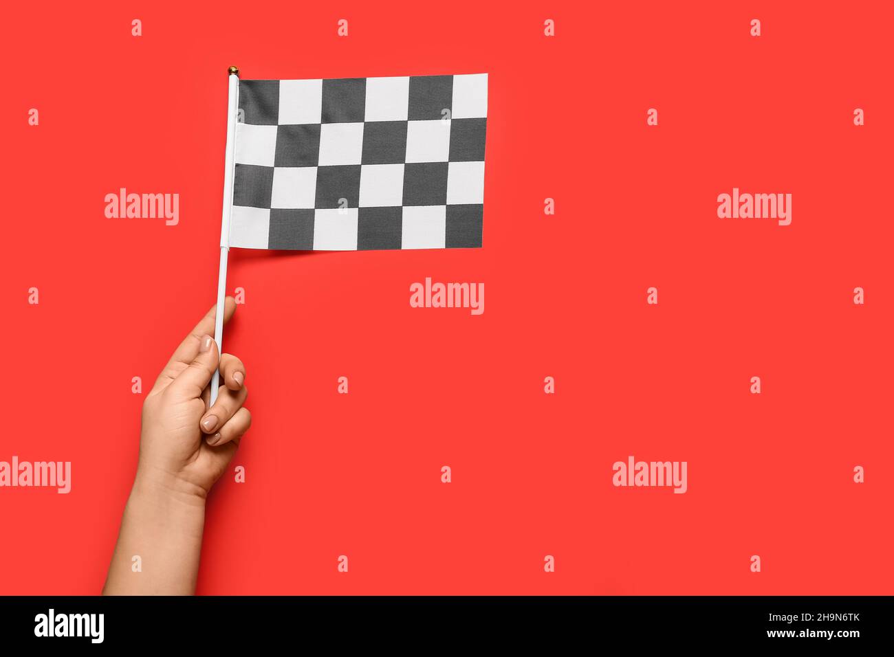 Female hand with racing flag on color background Stock Photo - Alamy