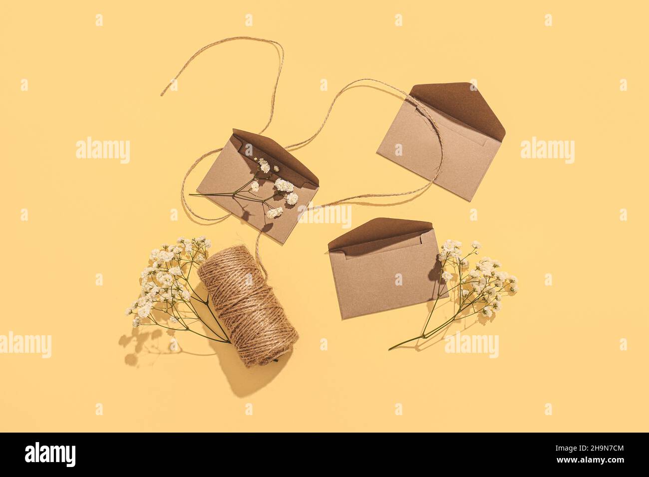 Rope, envelopes and beautiful gypsophila flowers on color background ...