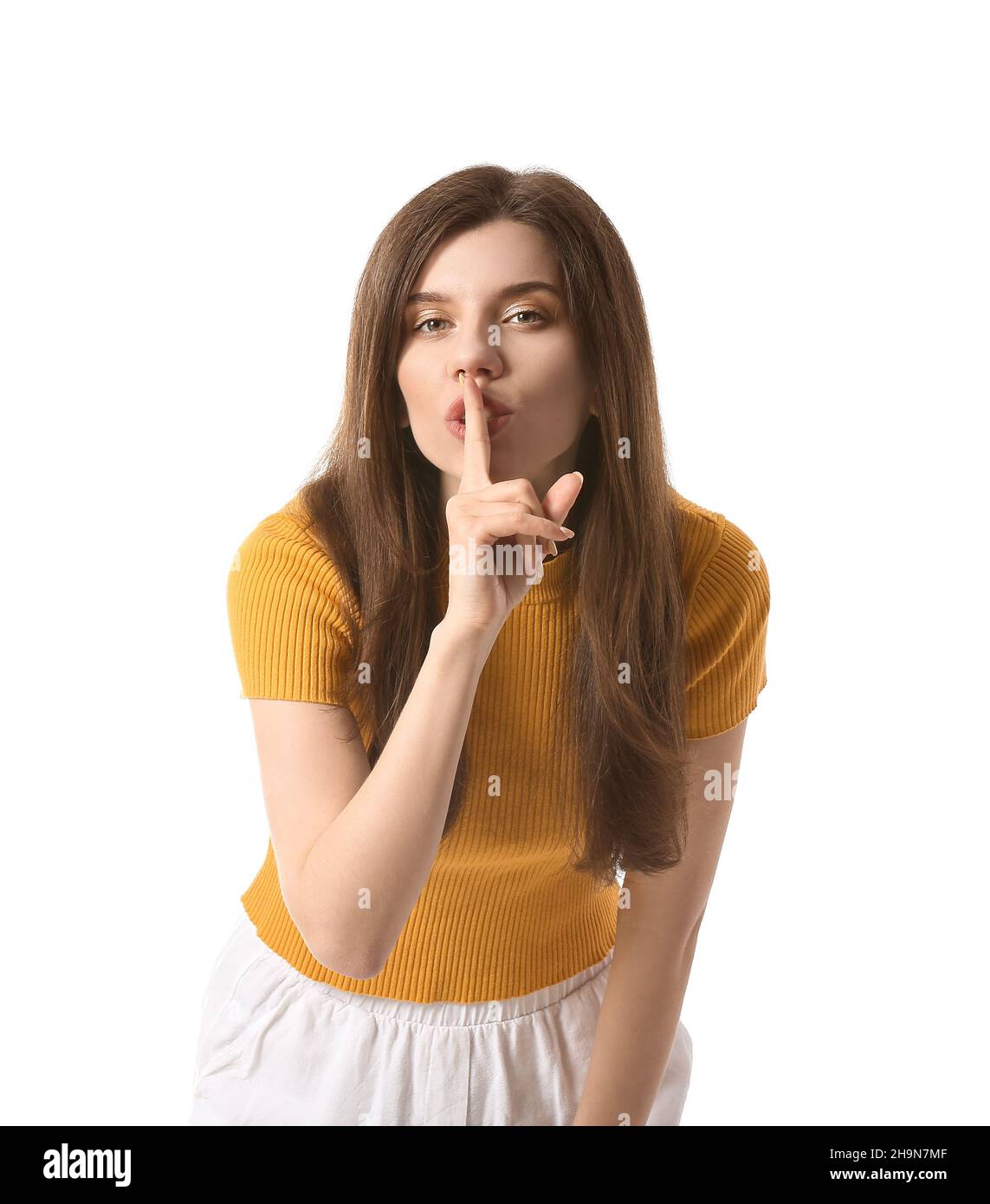 Young woman showing silence gesture on white background Stock Photo - Alamy