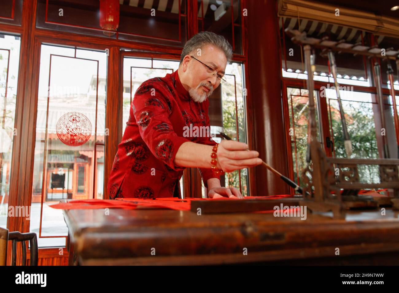 Older men write calligraphy Stock Photo - Alamy