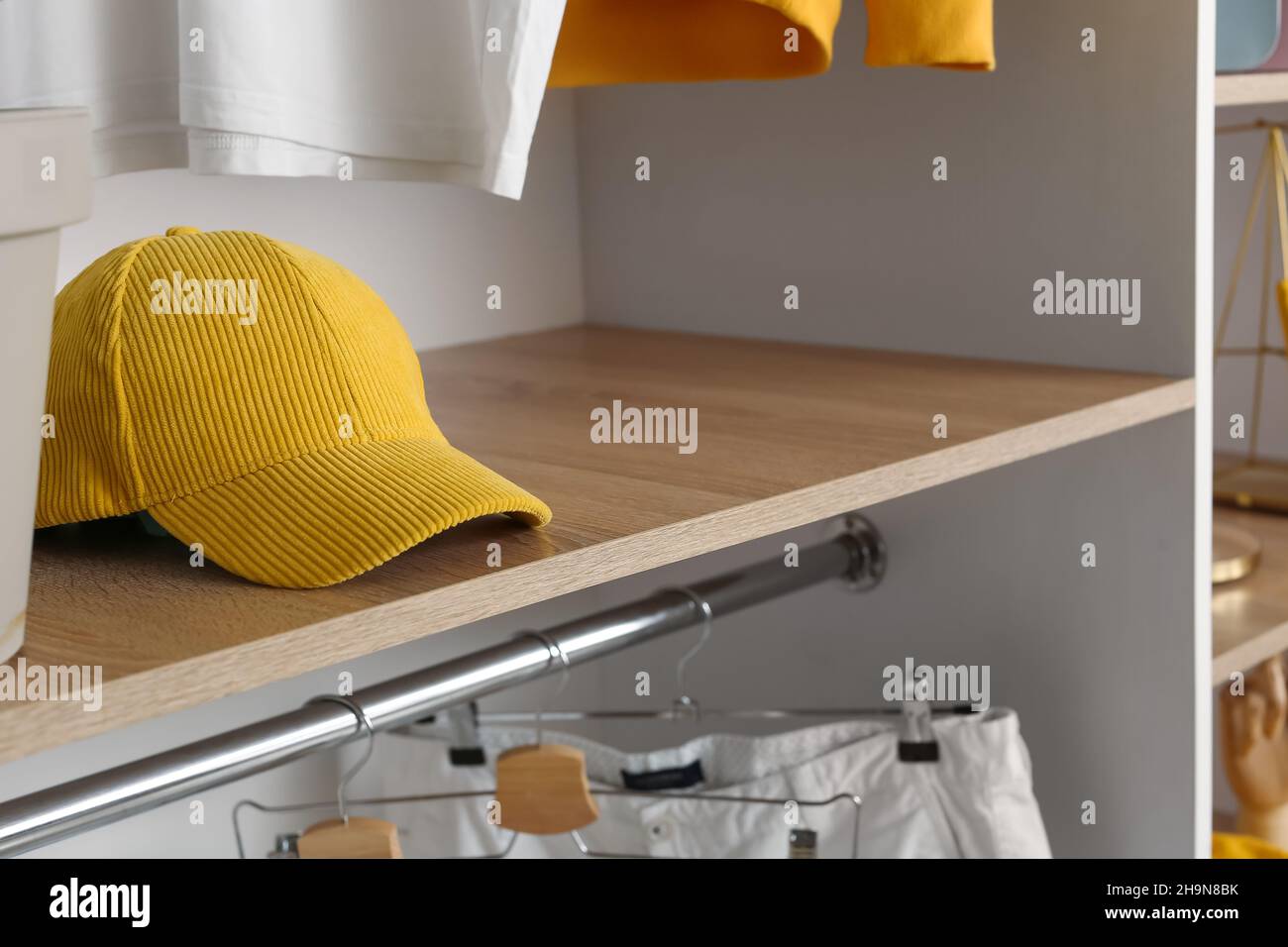 Stylish cap on shelf in wardrobe Stock Photo - Alamy