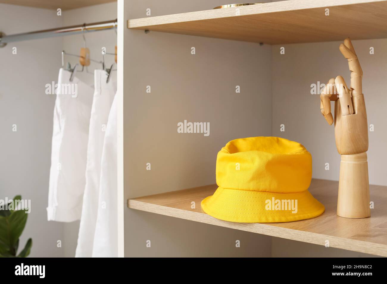 Stylish panama and wooden hand on shelf in wardrobe Stock Photo - Alamy