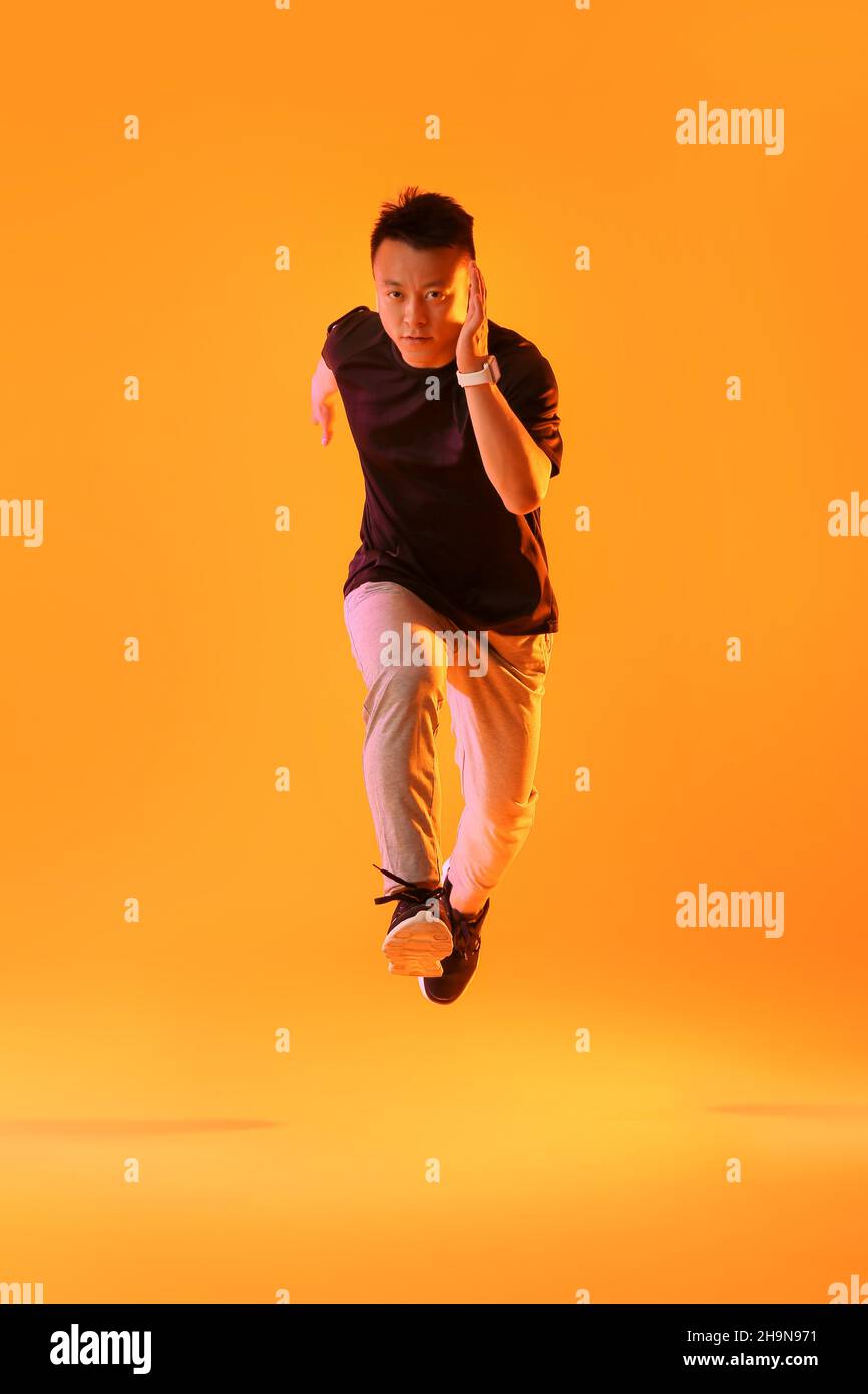 Sporty male runner on color background Stock Photo - Alamy