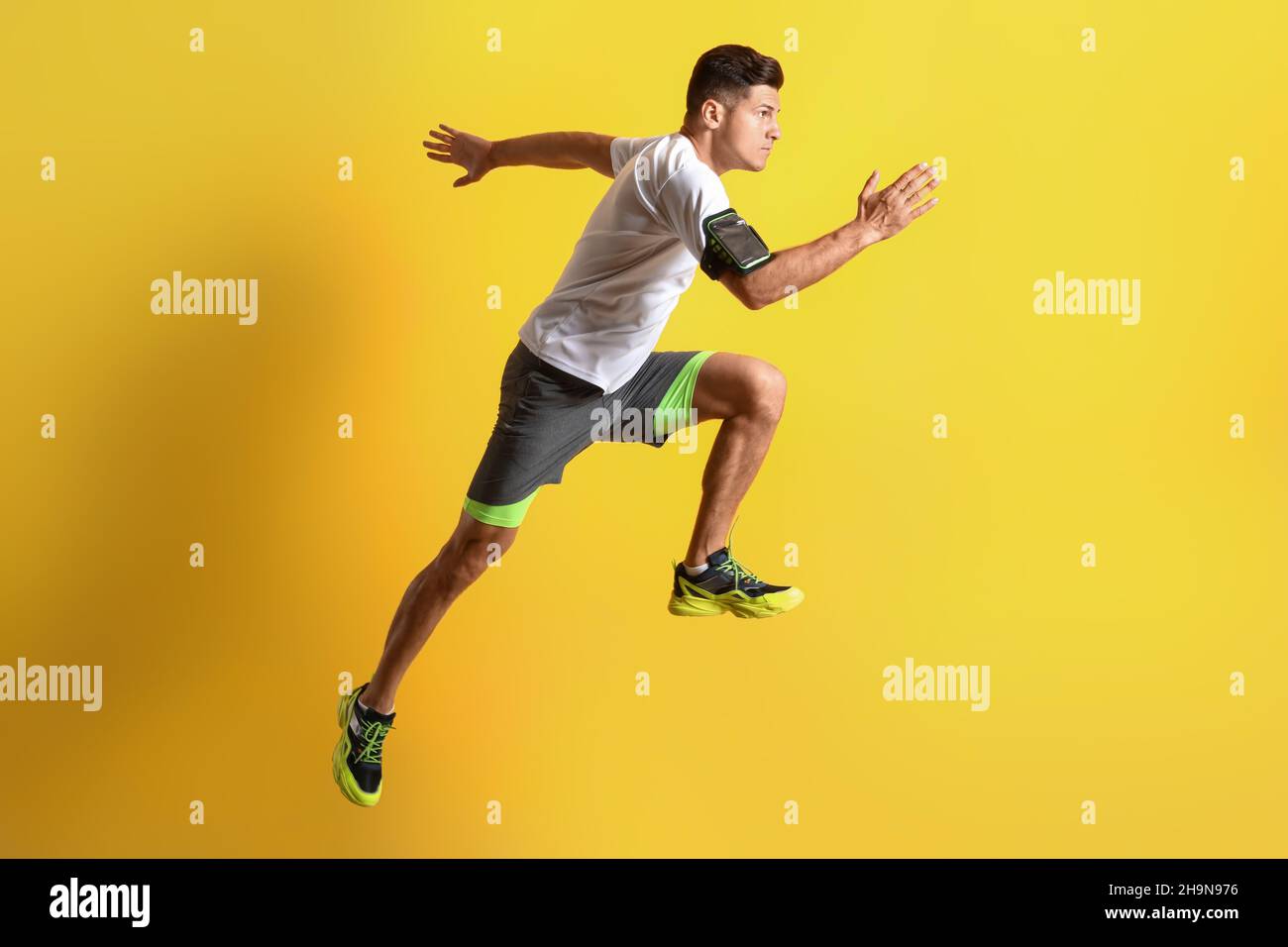 Sporty male runner on color background Stock Photo - Alamy