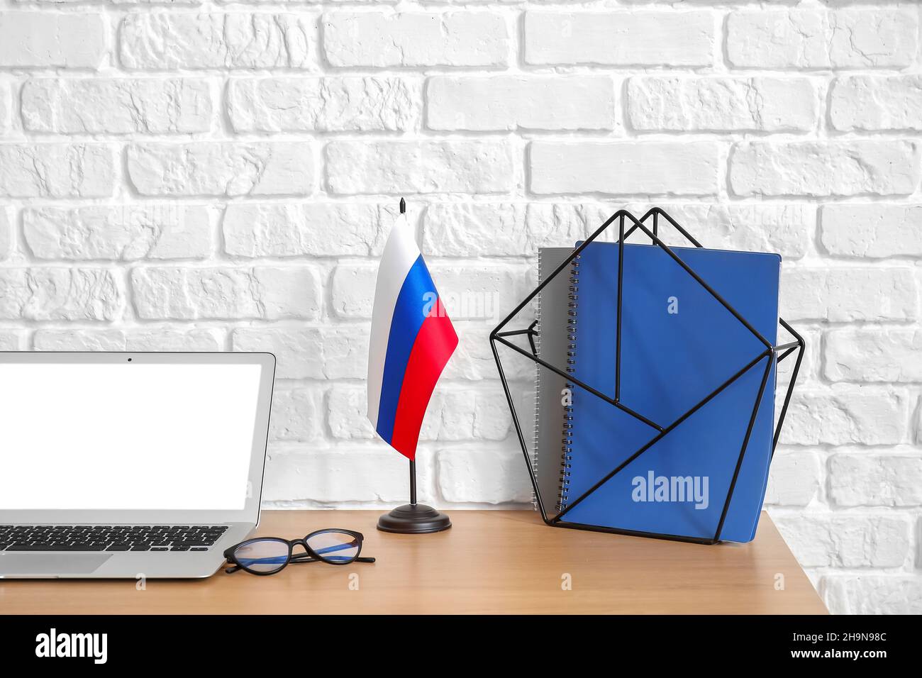 Modern workplace with Russian flag near brick wall Stock Photo - Alamy
