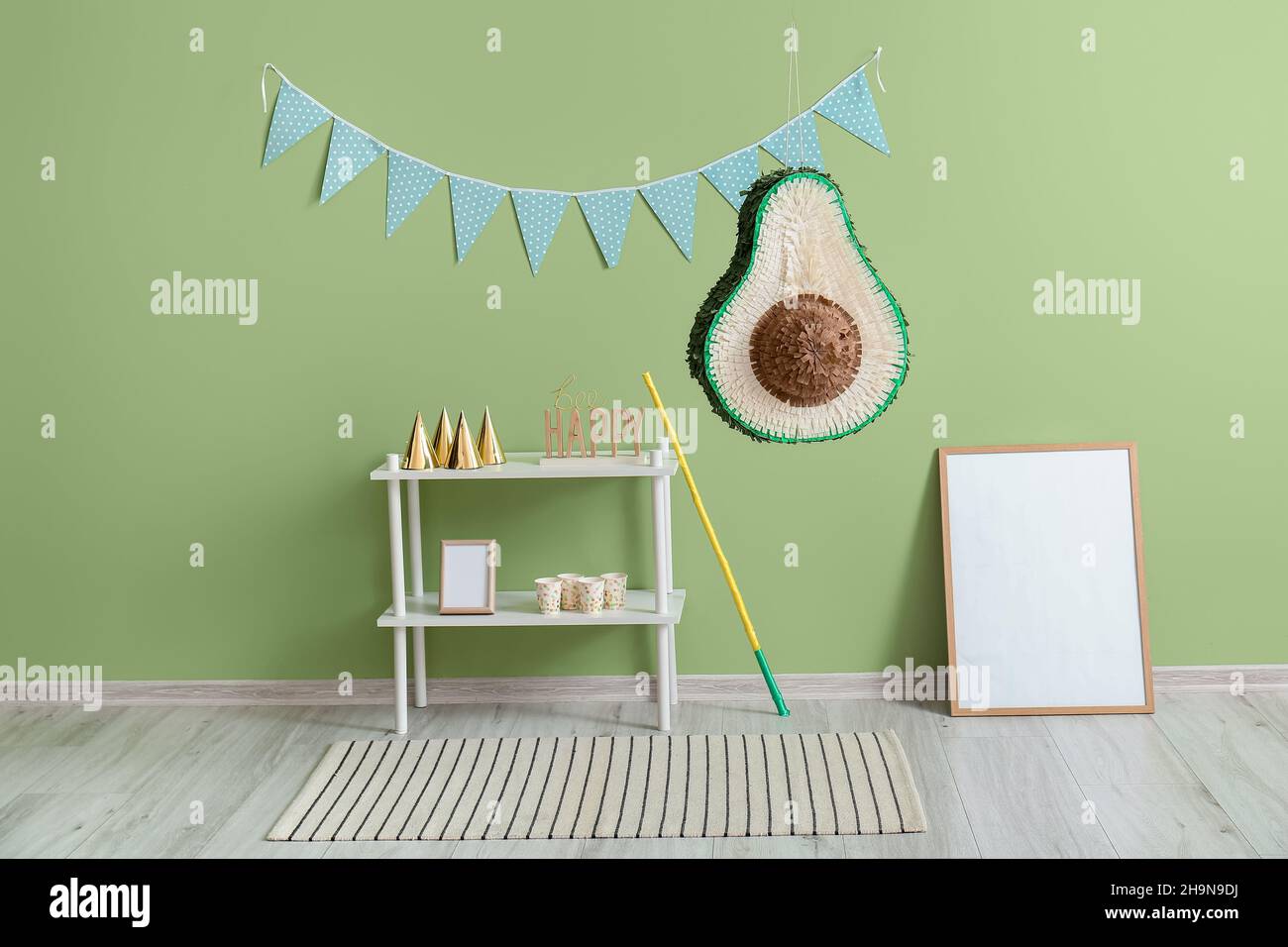 Interior of stylish room with shelving unit and hanging Mexican pinata ...