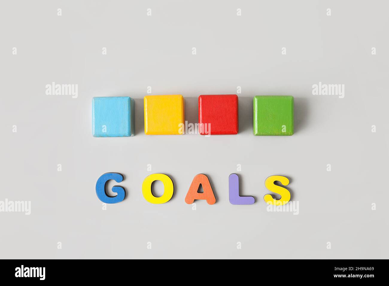Different color wooden cubes and word GOALS on grey background Stock ...