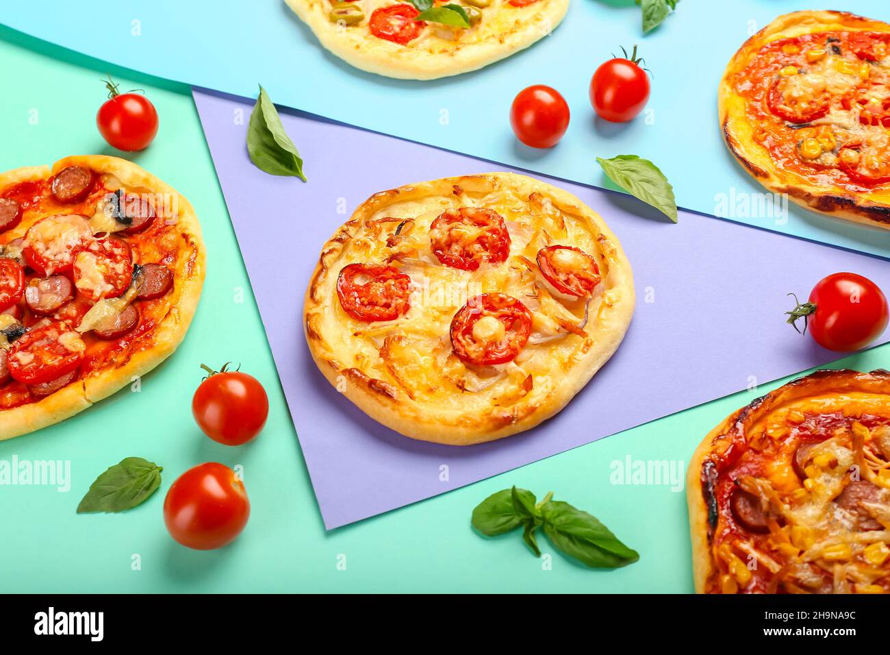 Delicious mini pizzas on color background Stock Photo - Alamy