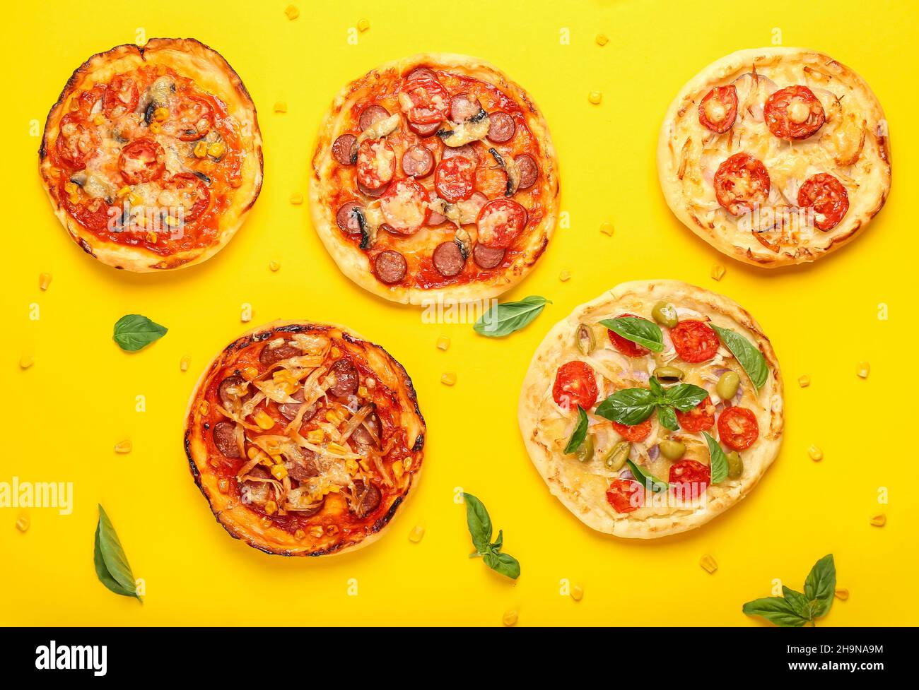 Delicious mini pizzas on yellow background Stock Photo - Alamy