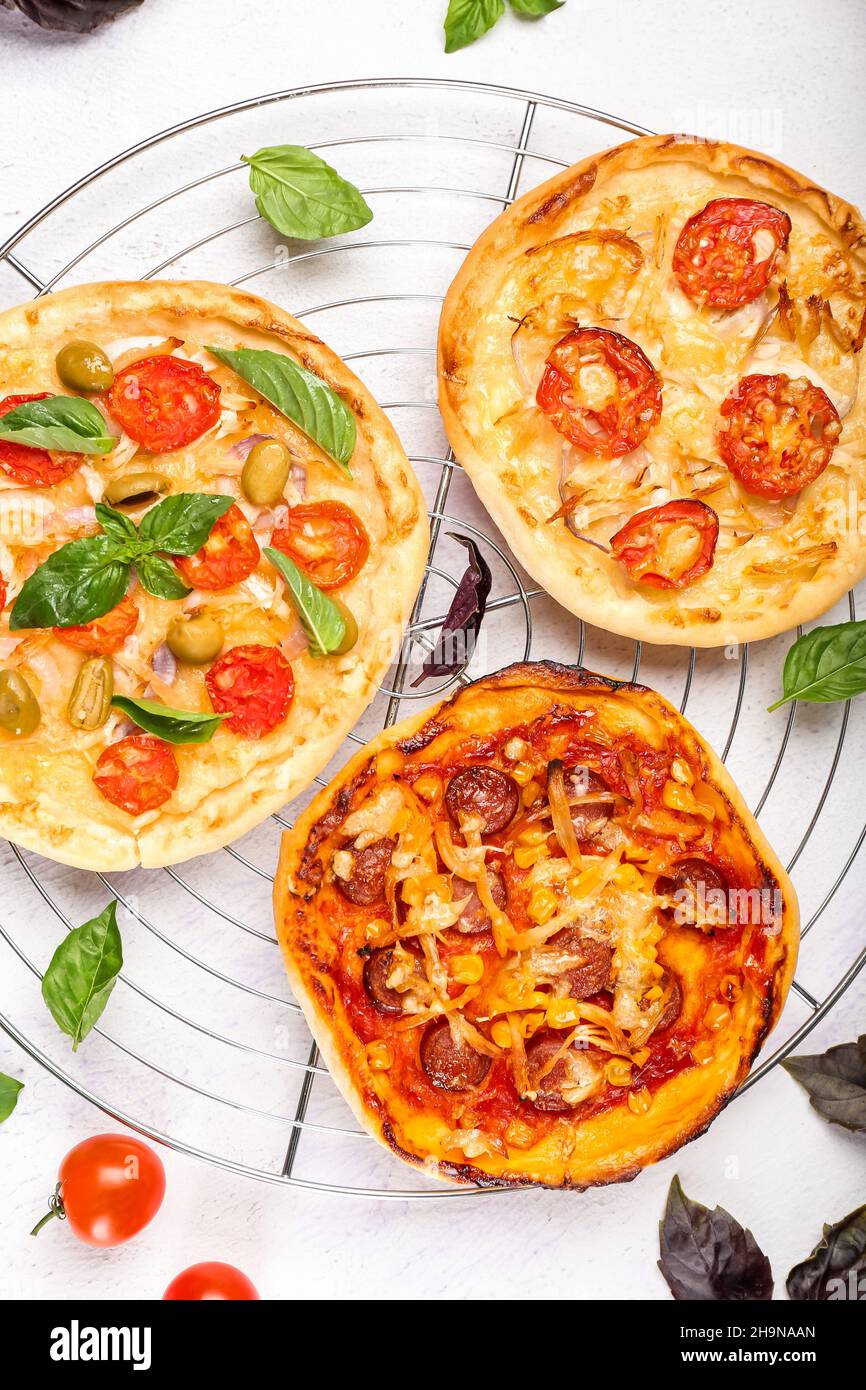 Grid with delicious mini pizzas on light background Stock Photo - Alamy