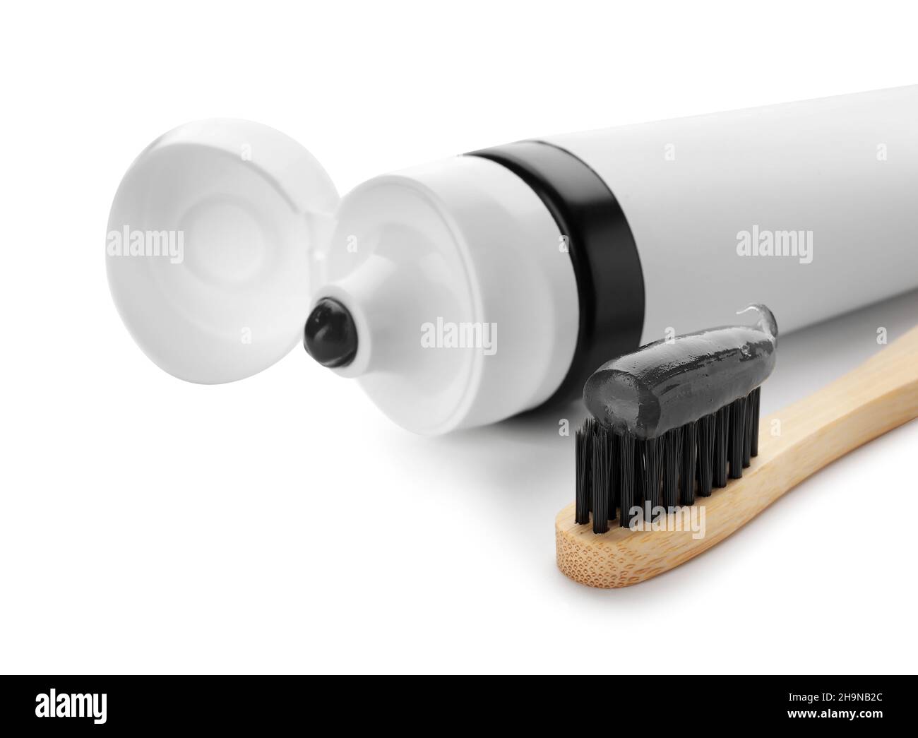 Tube with black tooth paste and brush on white background Stock Photo ...
