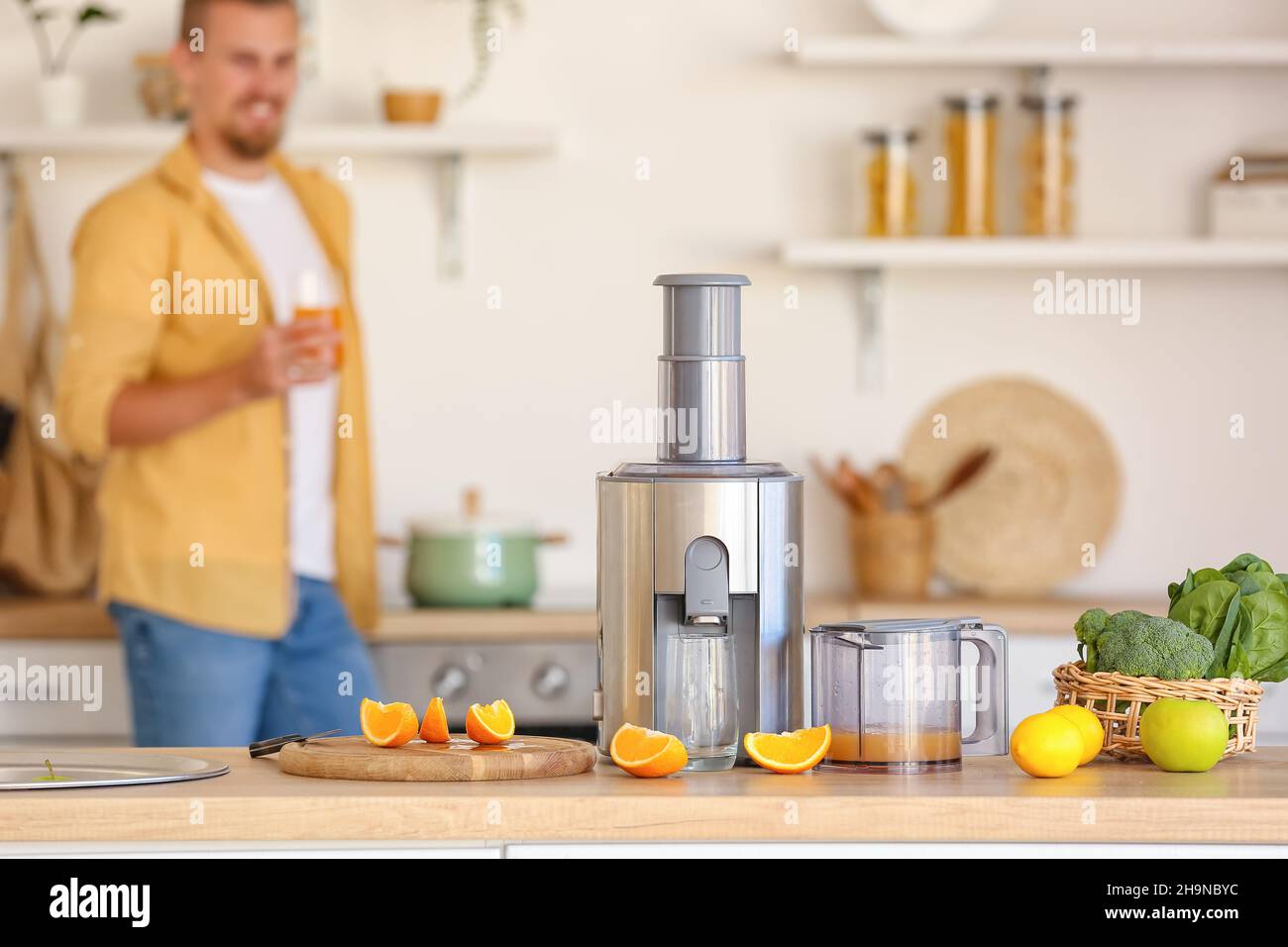 Modern juicer with cut fresh oranges on table in kitchen Stock Photo ...
