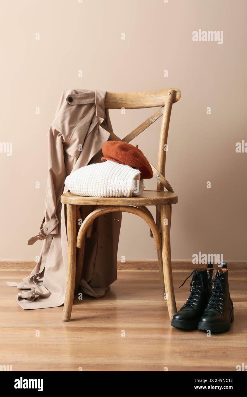 Stylish winter clothes with chair in room Stock Photo - Alamy