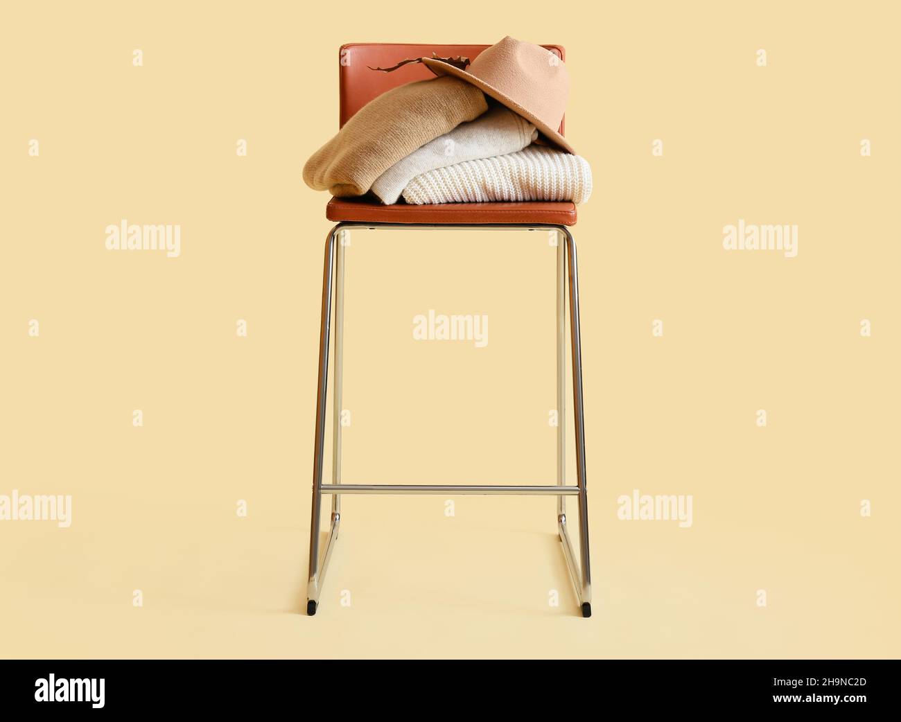 Stylish winter clothes on chair against color background Stock Photo ...