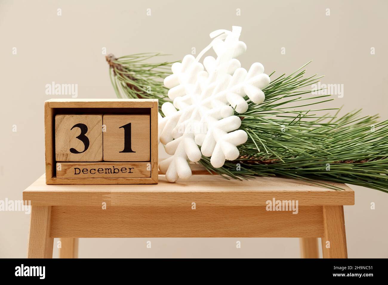 Wooden cube calendar with date DECEMBER 31, pine tree branch and ...