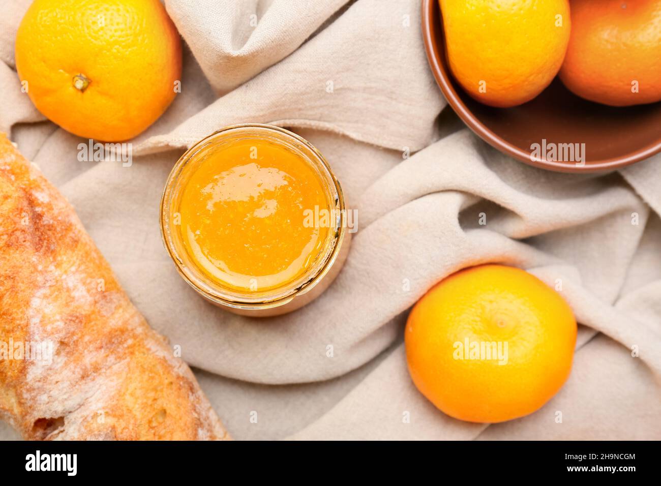 Jar of tasty tangerine jam and bread on table Stock Photo - Alamy