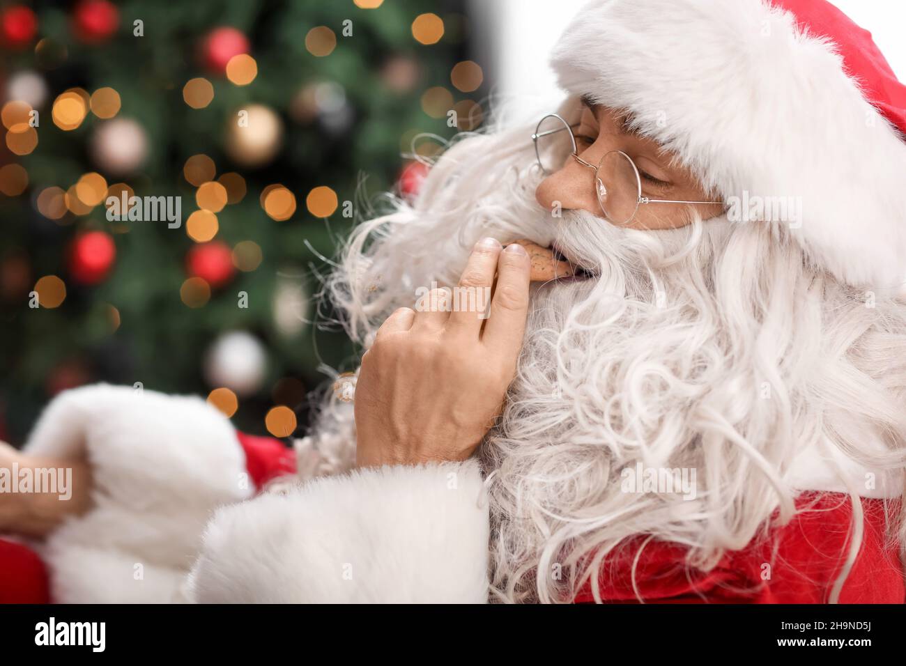 Santa Claus eating tasty cookies at home Stock Photo - Alamy