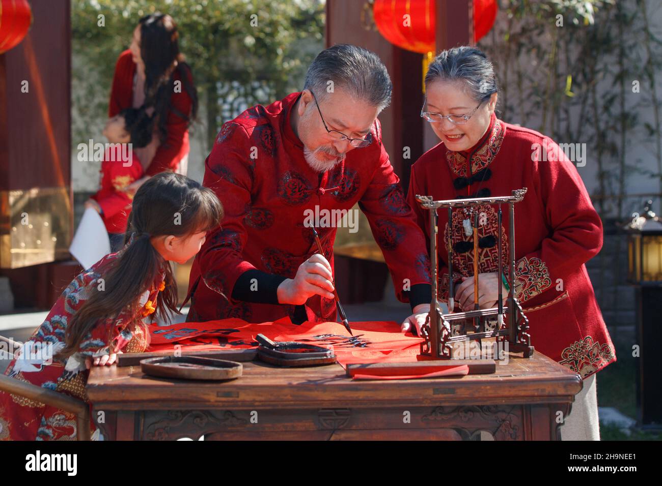 Happy New Year family write Spring Festival couplets Stock Photo - Alamy