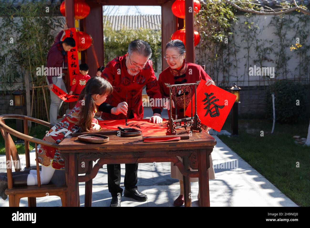 Happy New Year family write Spring Festival couplets Stock Photo - Alamy
