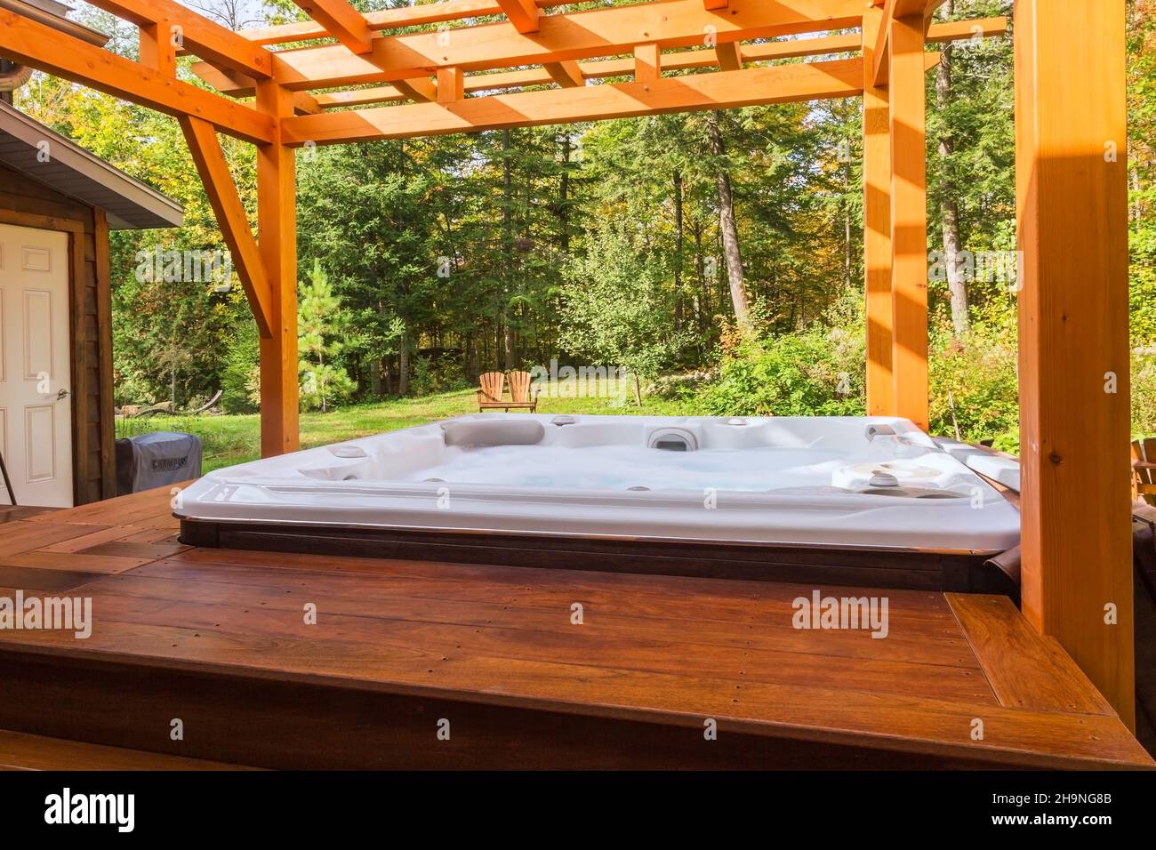 Oiled Eastern white pine timber frame pergola and spa on raised wood ...