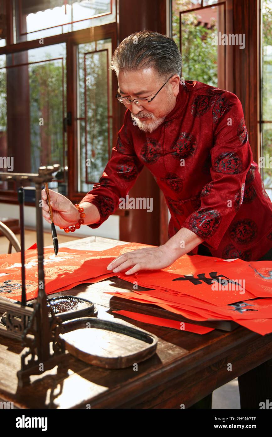 Older men write calligraphy Stock Photo - Alamy