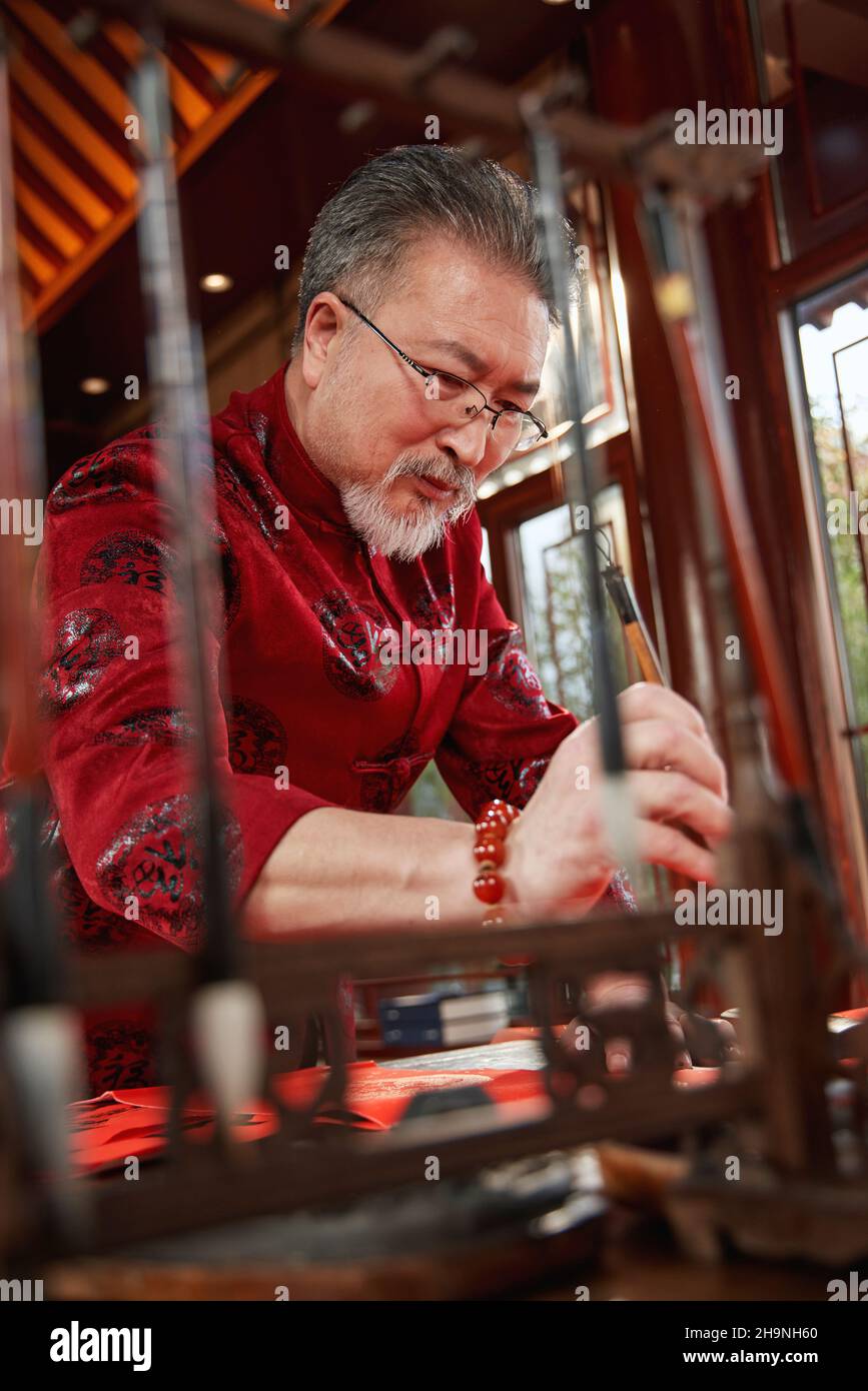 Older men write calligraphy Stock Photo - Alamy