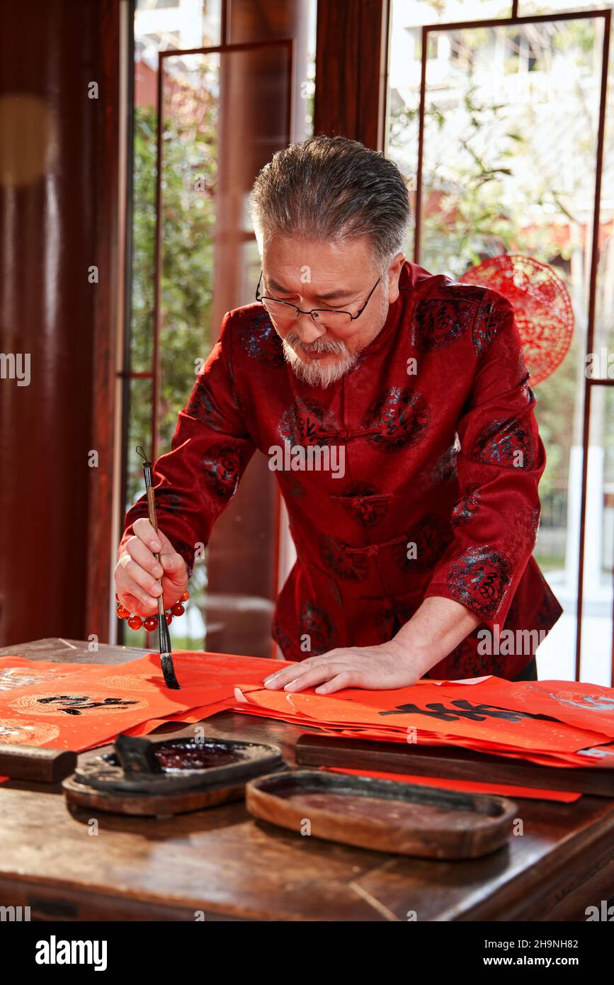 Older men write calligraphy Stock Photo - Alamy