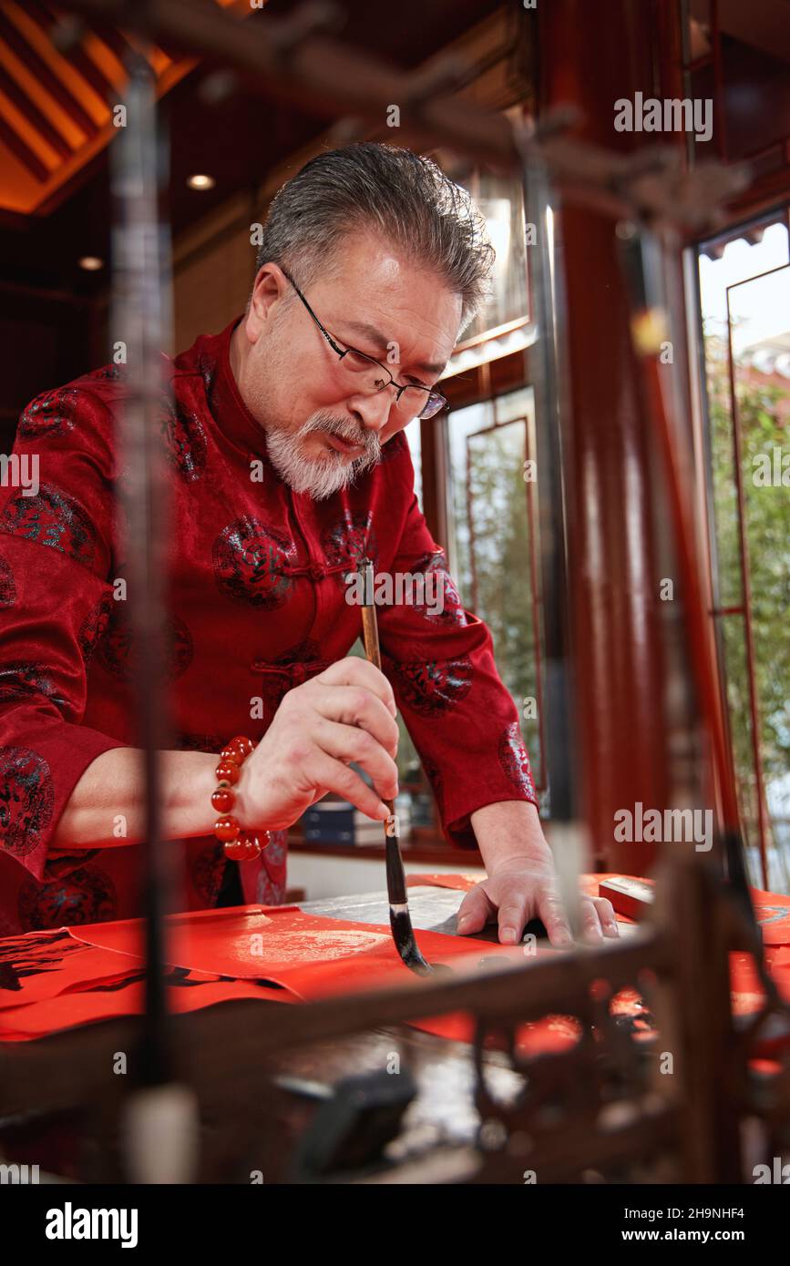 Older men write calligraphy Stock Photo - Alamy