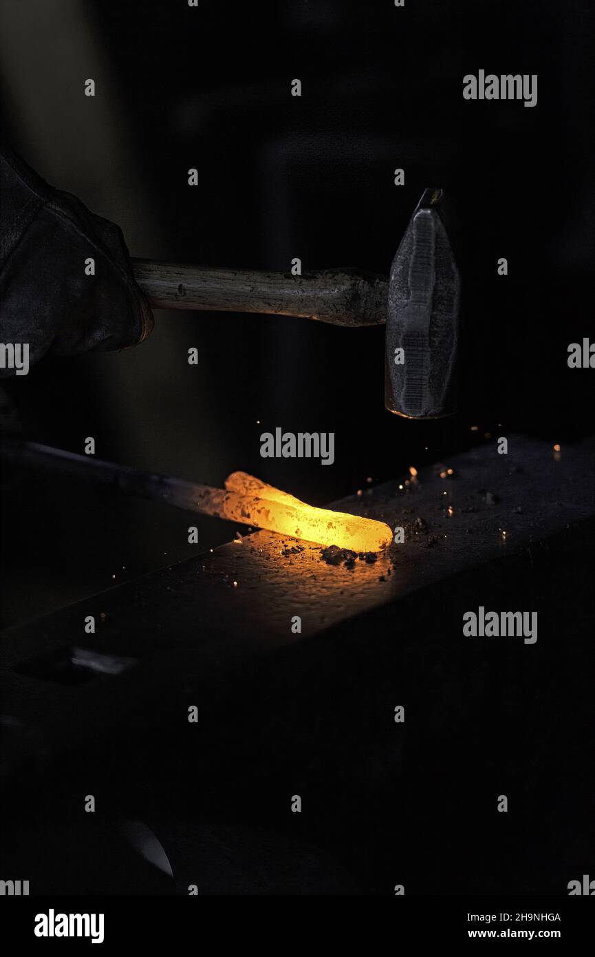 Blacksmith with hammer and anvil at work Stock Photo - Alamy