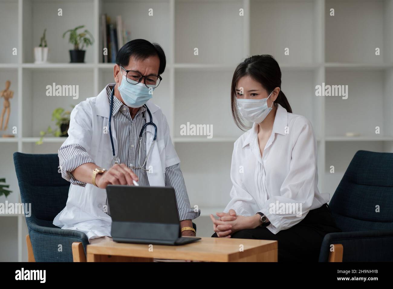 Senior doctor wearing safety protective mask supporting and cheering up ...