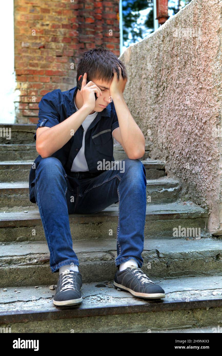 Sad Teenager with Cellphone on the landing steps of the Old House Stock ...