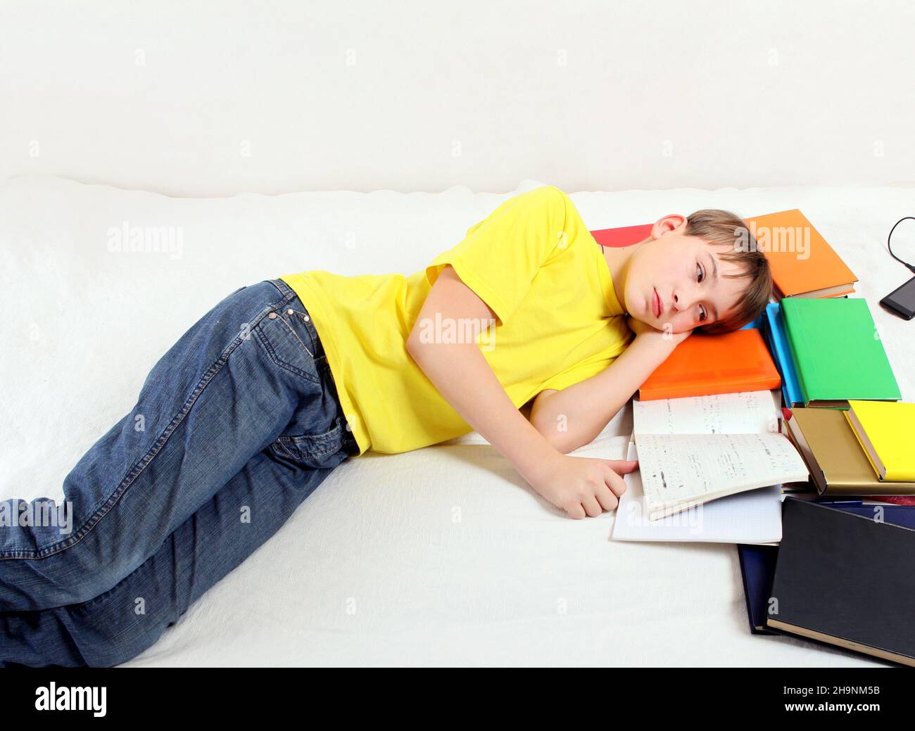 Sad and Tired Kid with the Books on the Bed Stock Photo - Alamy