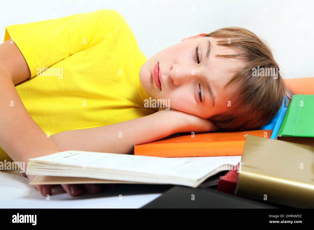 Sad and Tired Kid with the Books on the Bed Stock Photo - Alamy