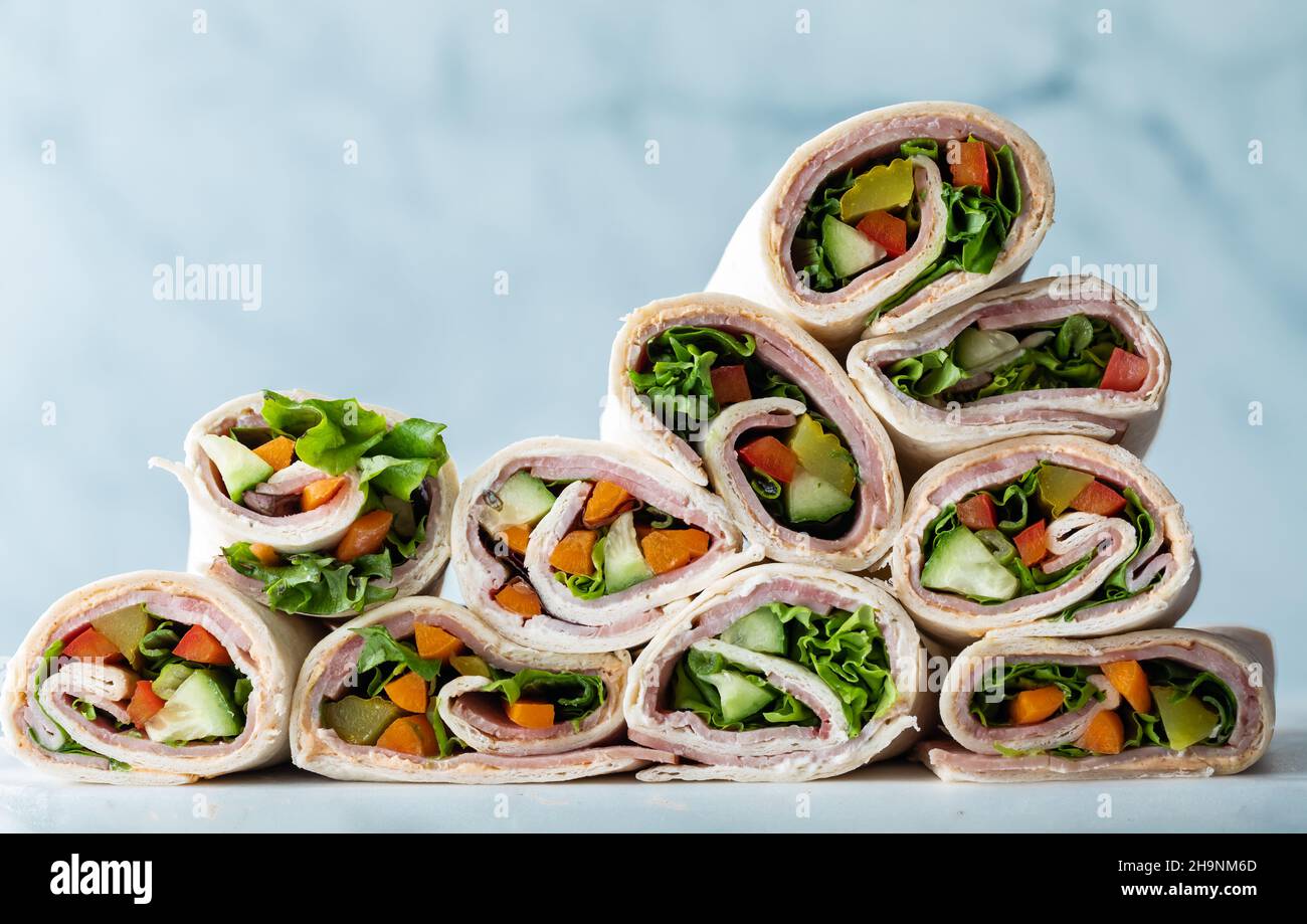 Close up front view of a pile of freshly made wraps, ready for eating ...