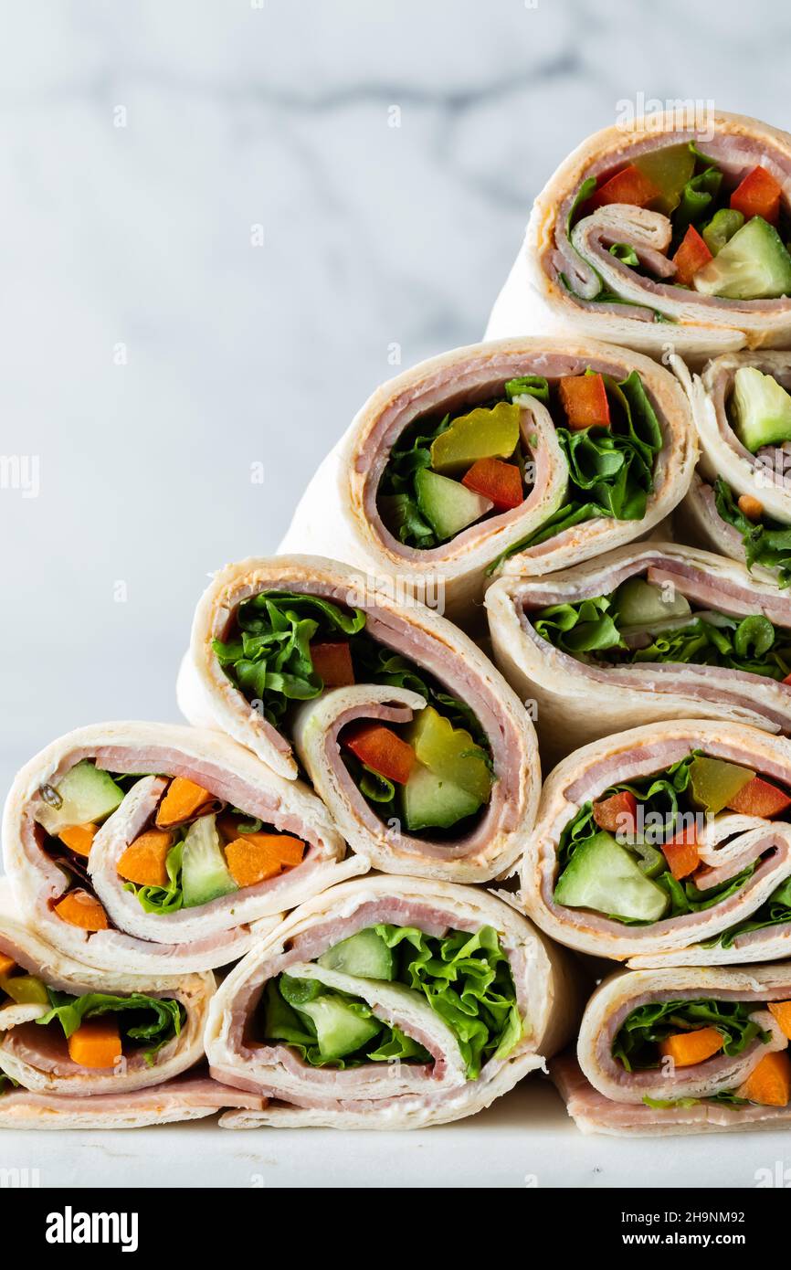 A front view of a stack piled high of freshly made wraps ready for ...