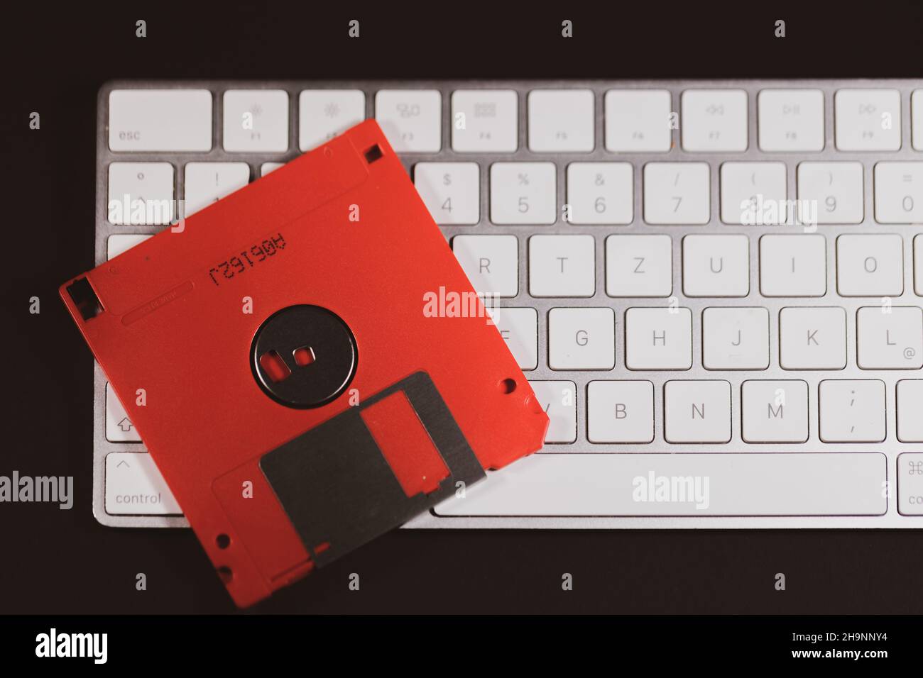 a red floppy disk lies on a white keyboard Stock Photo - Alamy