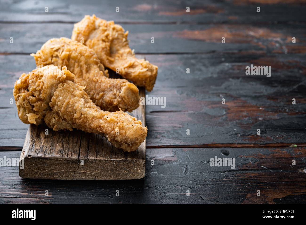 Chicken leg breaded and fried on dark wooden background, with space for ...