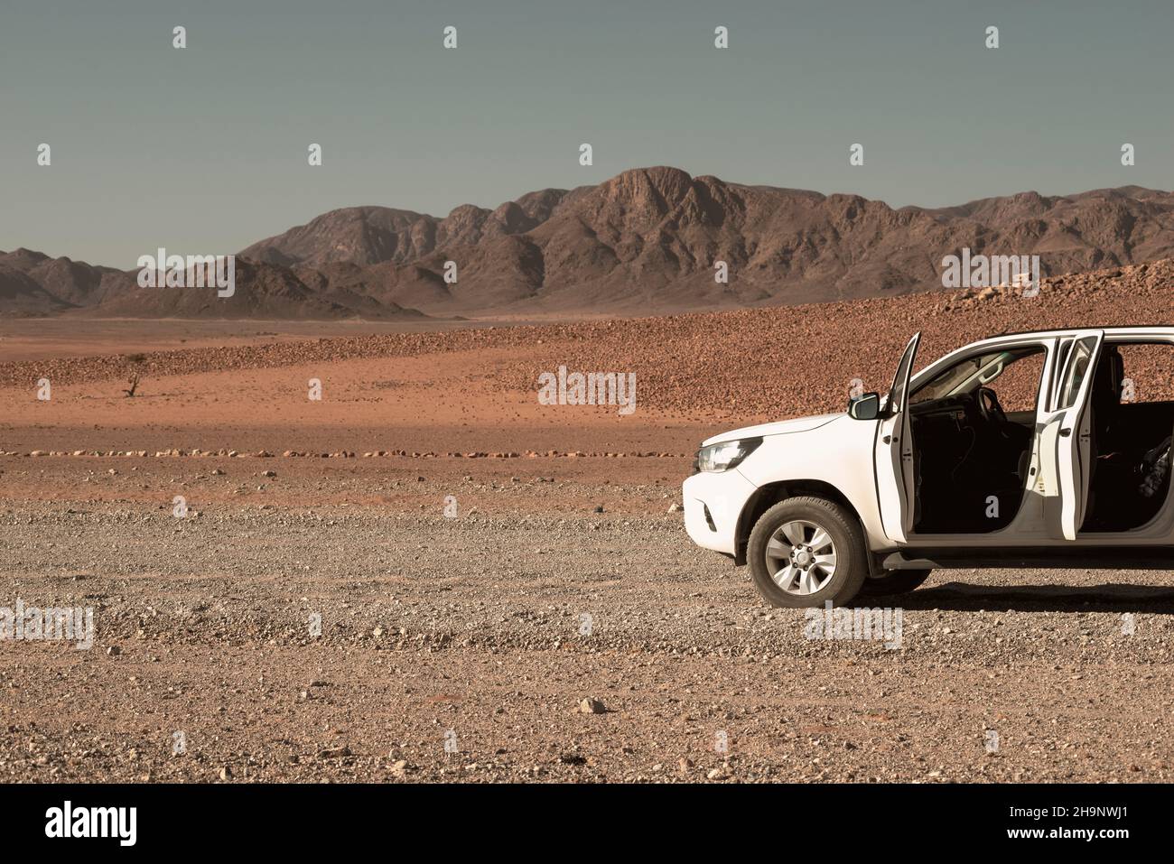 empty car with open doors ready for road trip in desert of Namibia ...