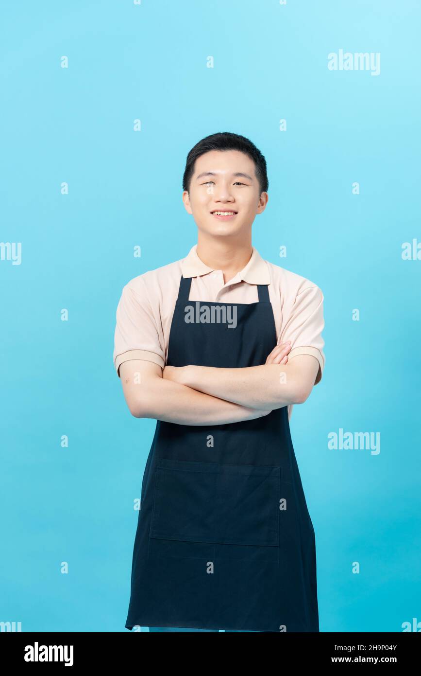 Handsome man in apron isolated on light blue background Stock Photo - Alamy