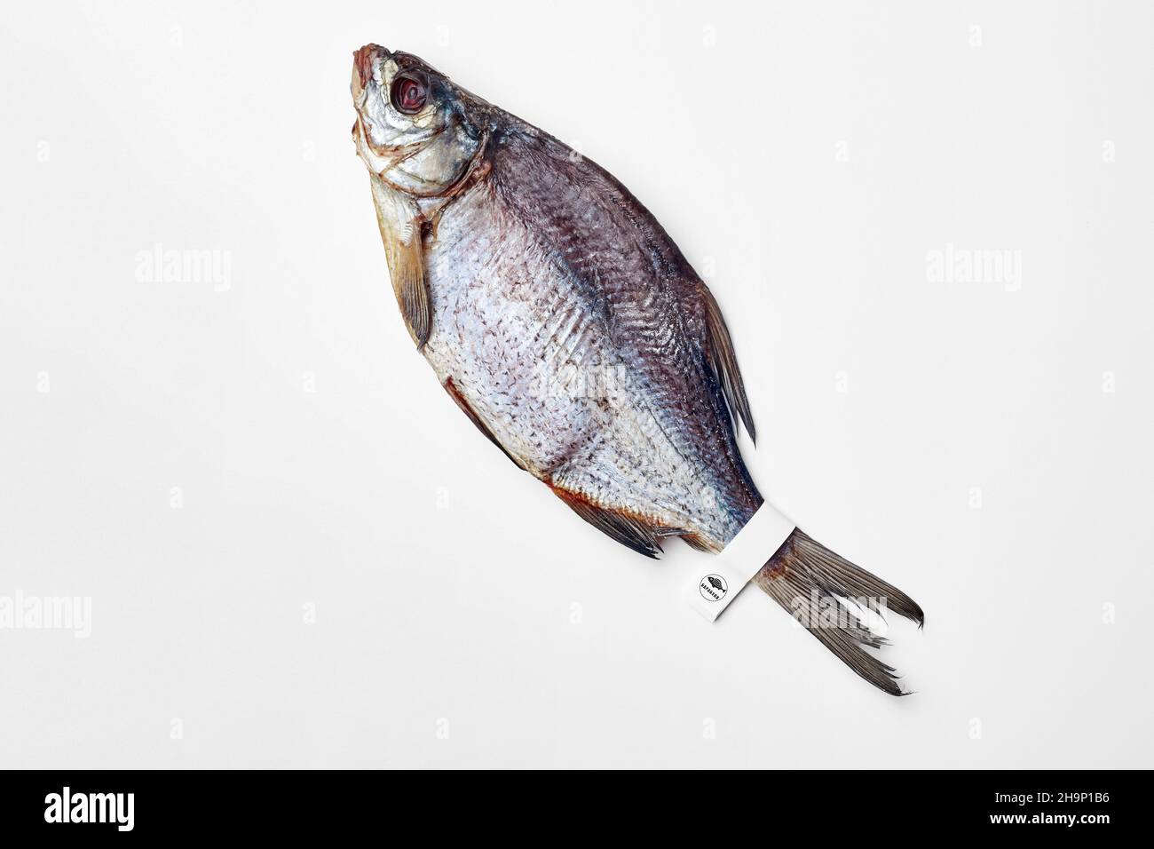 Whole salted sun-dried bream with label on tail on white surface Stock ...