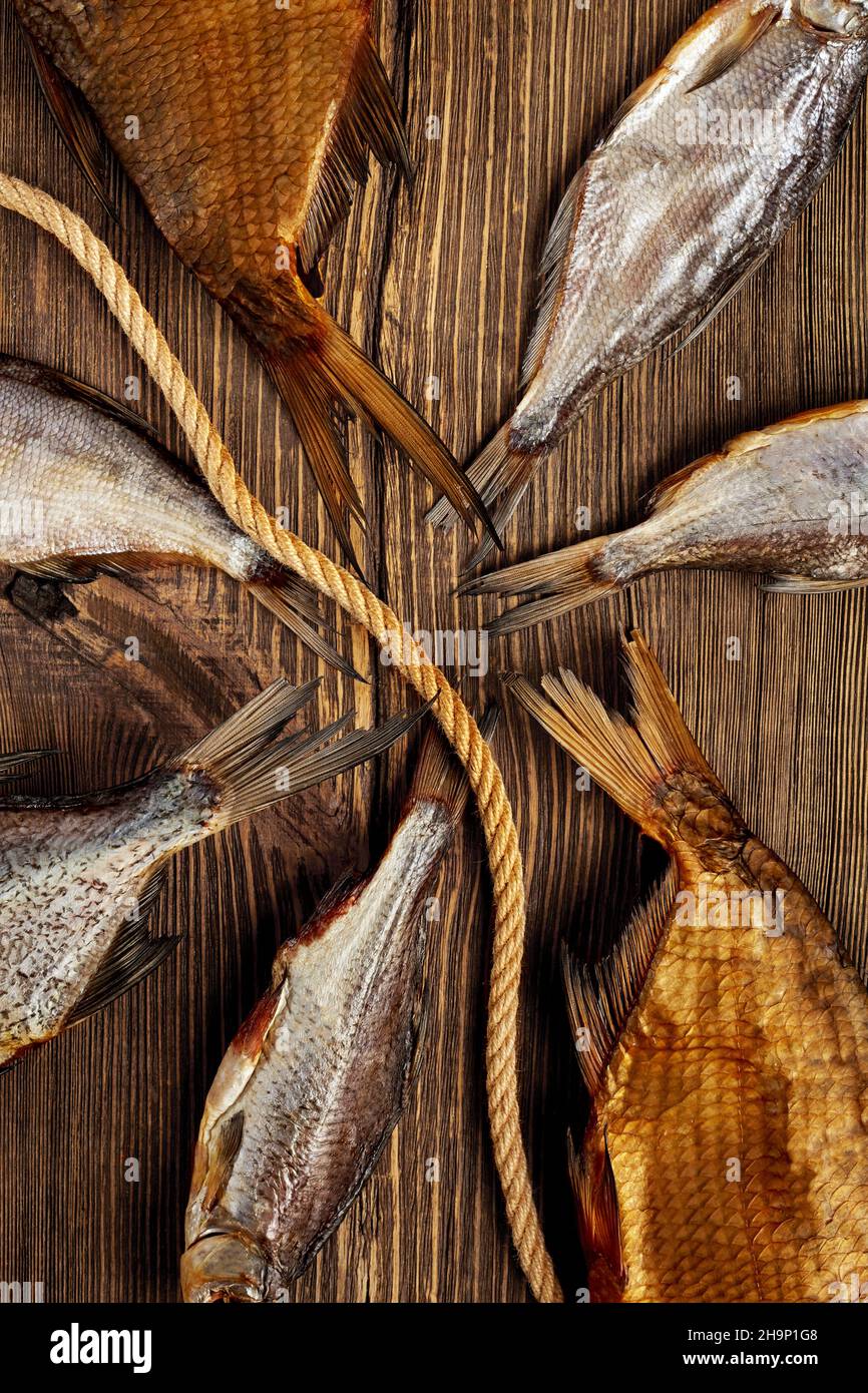 Tails of salted dried and smoked fish of different sizes on wooden ...