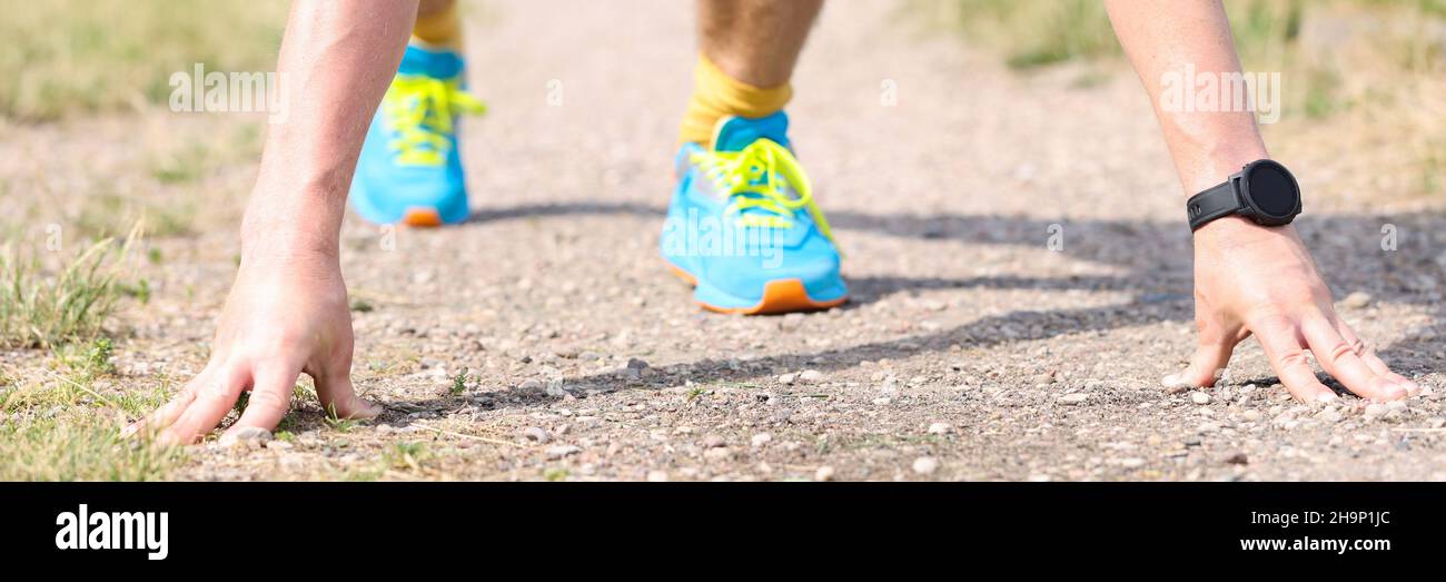 Active man in low starting position prepares for sprint in park Stock ...