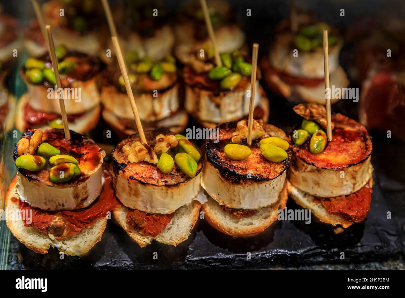 Traditional Spanish pintxos with goat cheese, pistachios, walnuts and ...