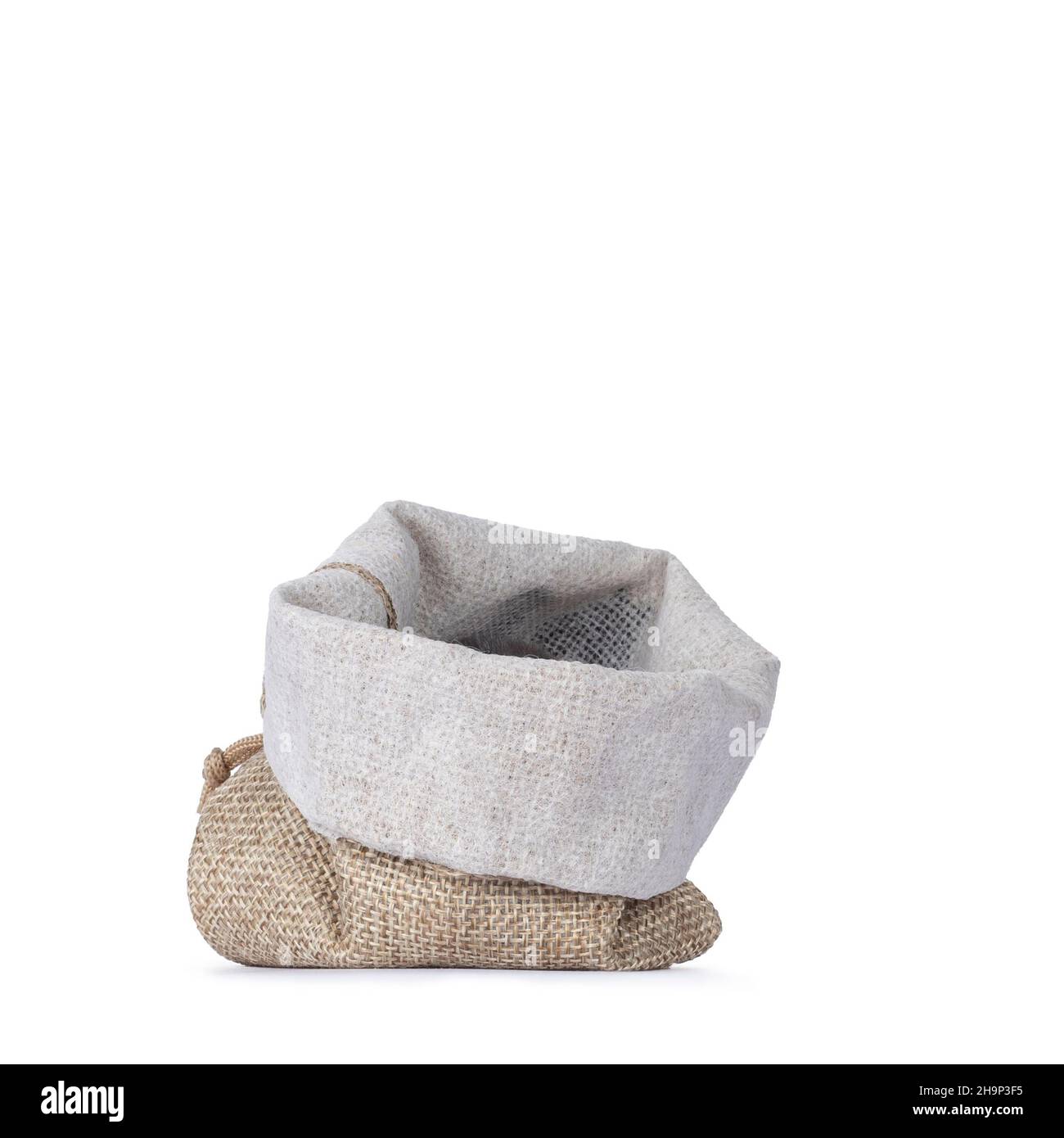 Little woven empty bag with folded edge, standing up. Isolated on a ...