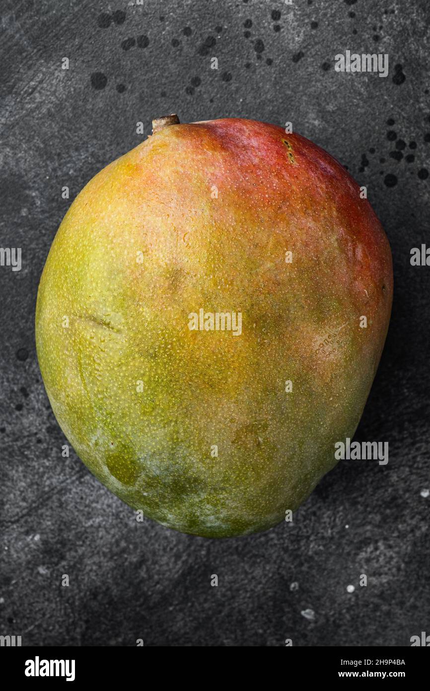 Whole ripe mango set, on black dark stone table background, top view ...