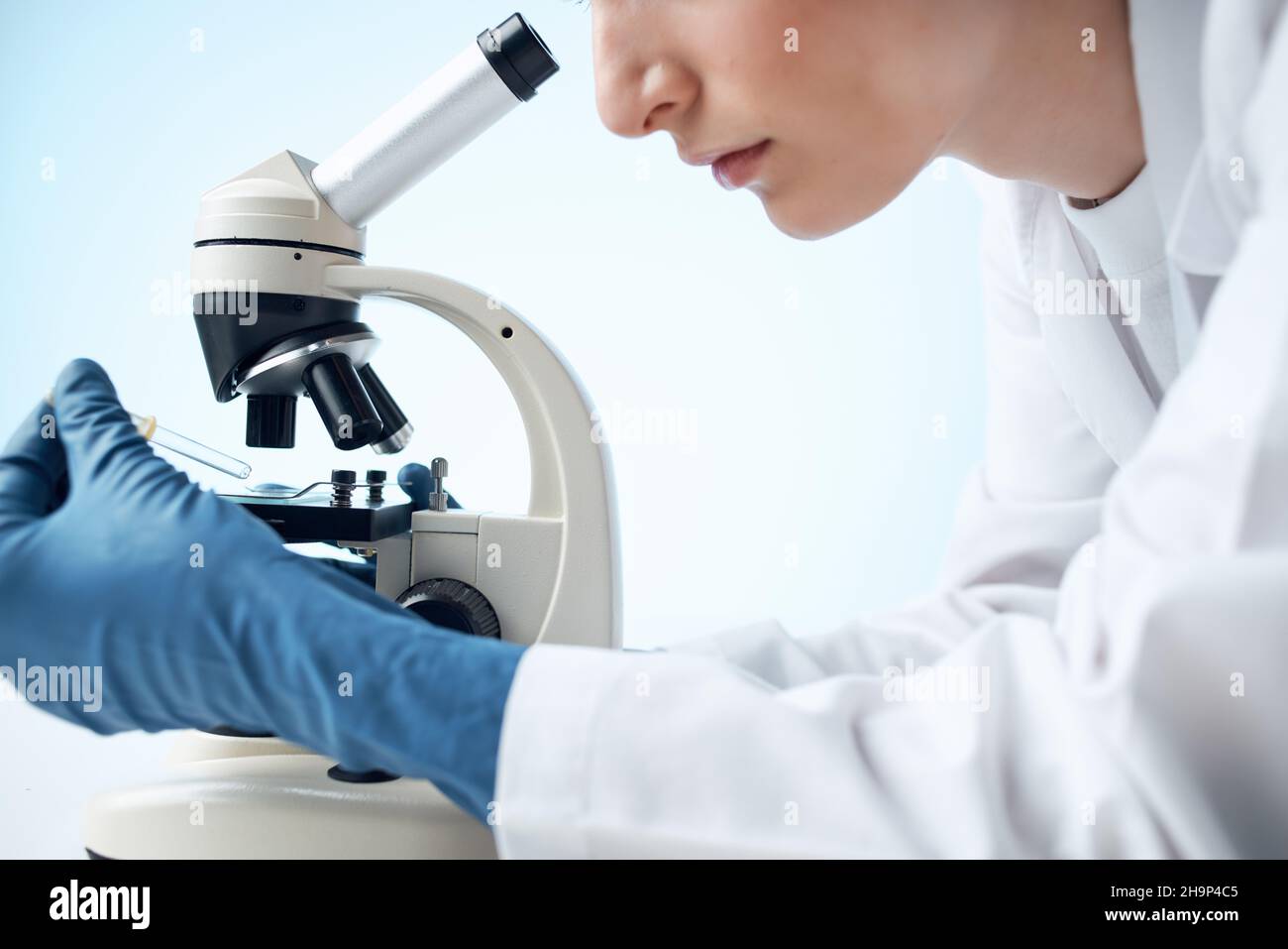 female doctor sitting at the table microscope research biotechnology ...